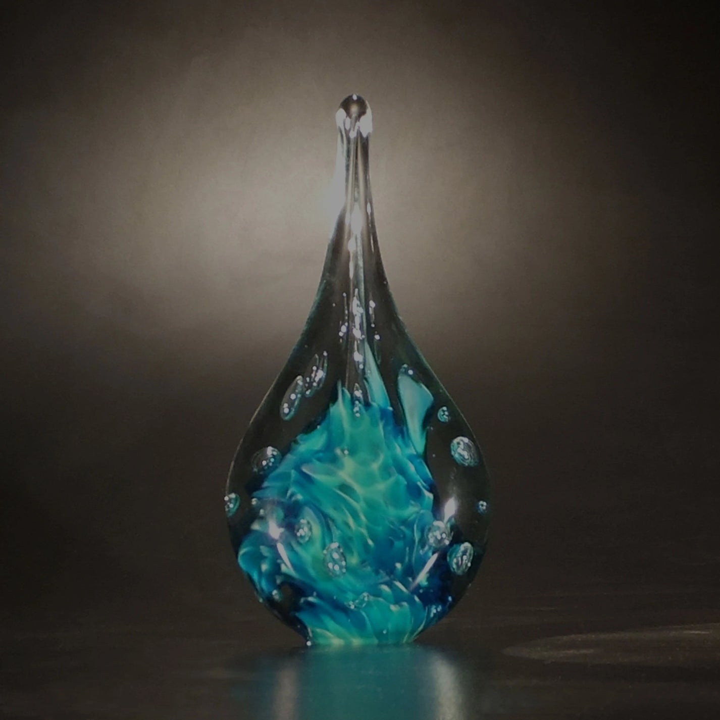 The Glass Forge Twisted Flame Paperweight Shown In Green And Blue ...